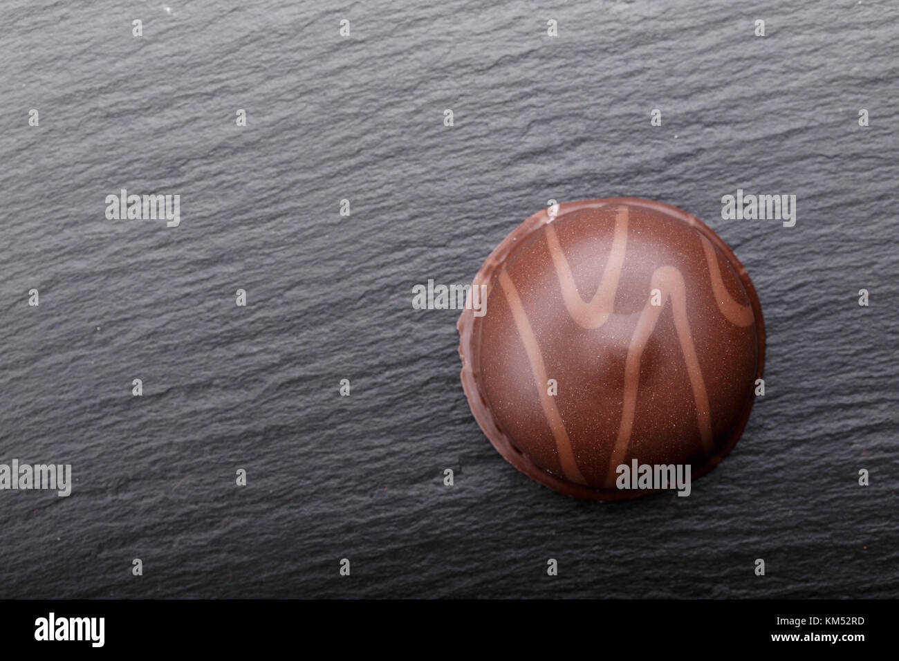 round chocolate candy on a black slate board Stock Photo - Alamy