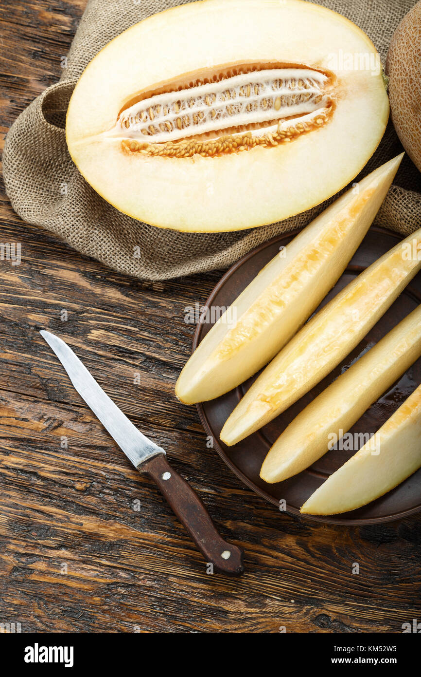 fresh juicy ripe melon cut into slices on , next to it is half a melon ...