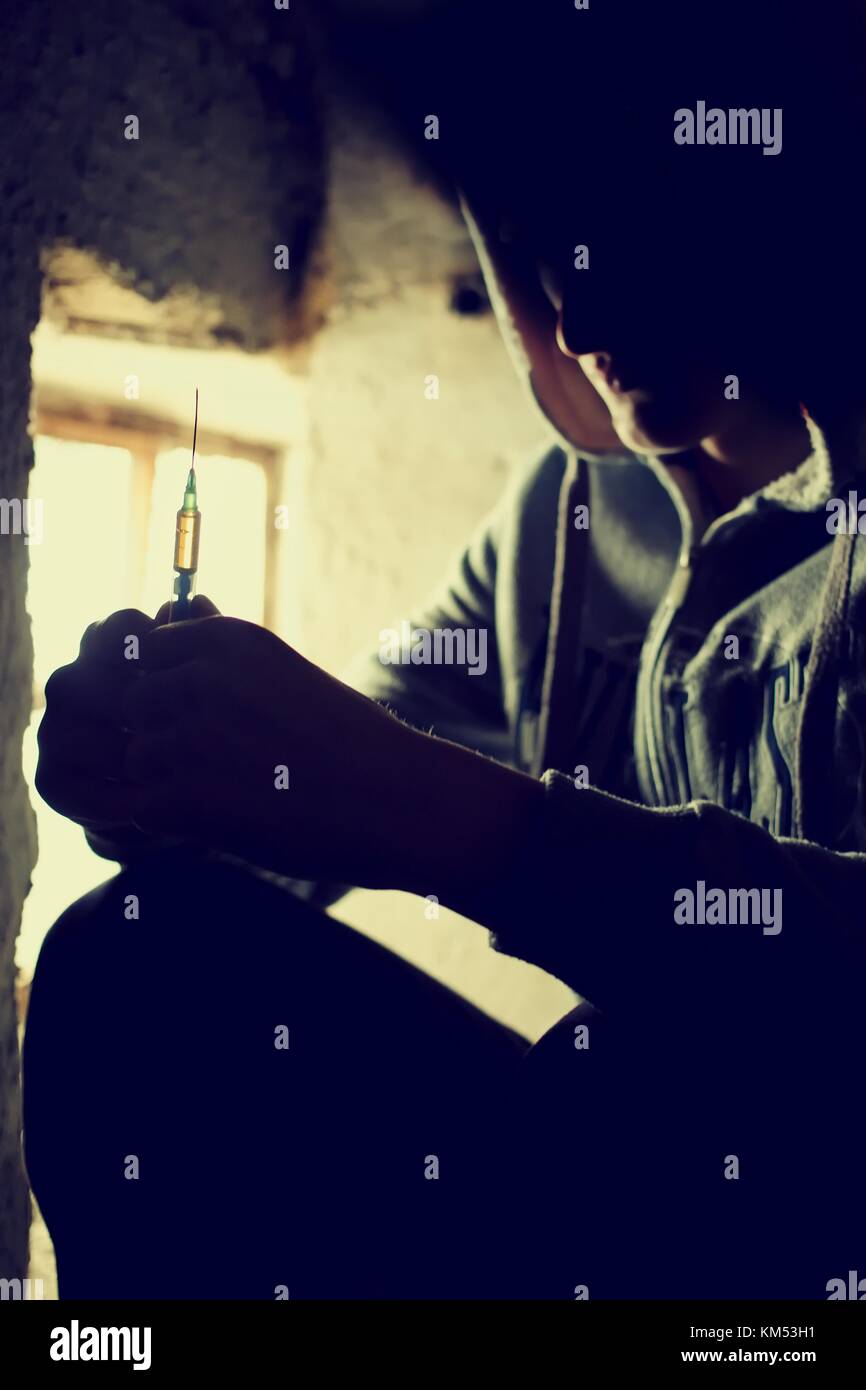 Drugs concept. Disease concept. Drug addict man with syringe using ...