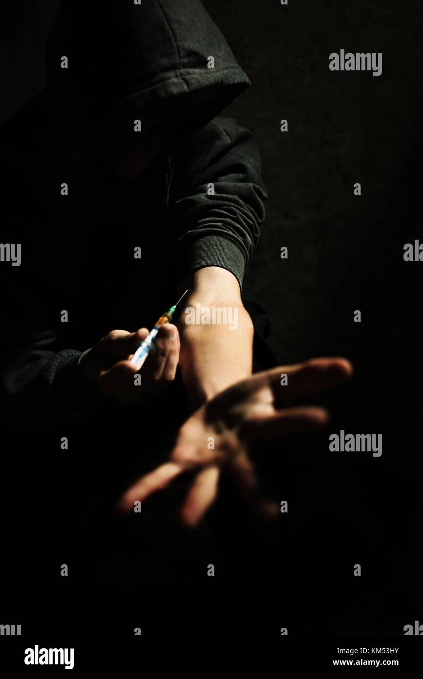 Drugs concept. Disease concept. Drug addict man with syringe using ...