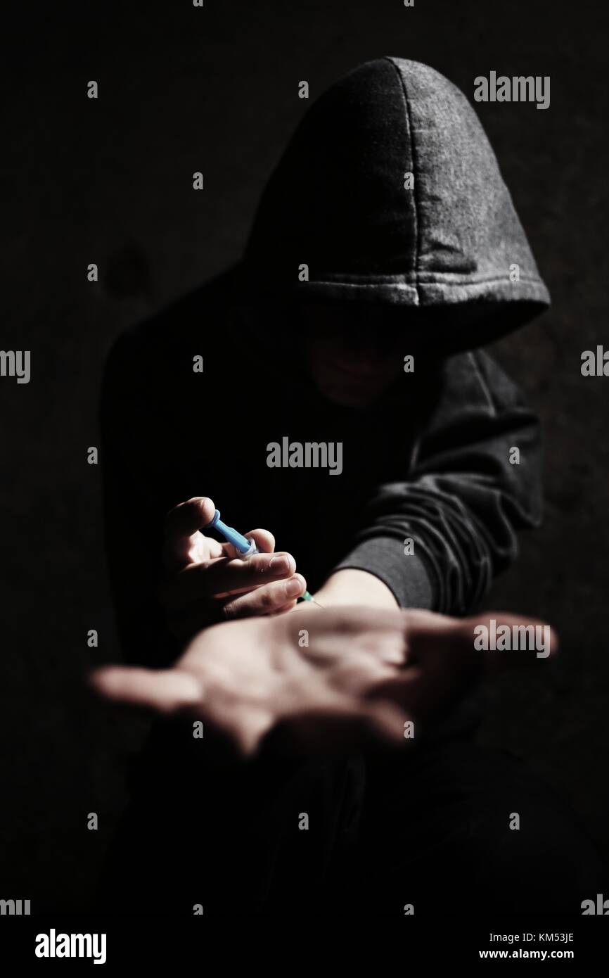 Drugs concept. Disease concept. Drug addict man with syringe using ...
