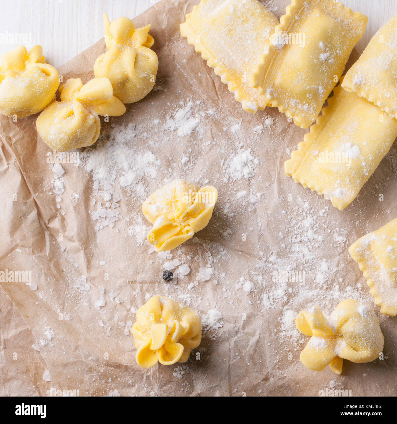 Top view on homemade pasta ravioli and perle on crumpled paper with ...