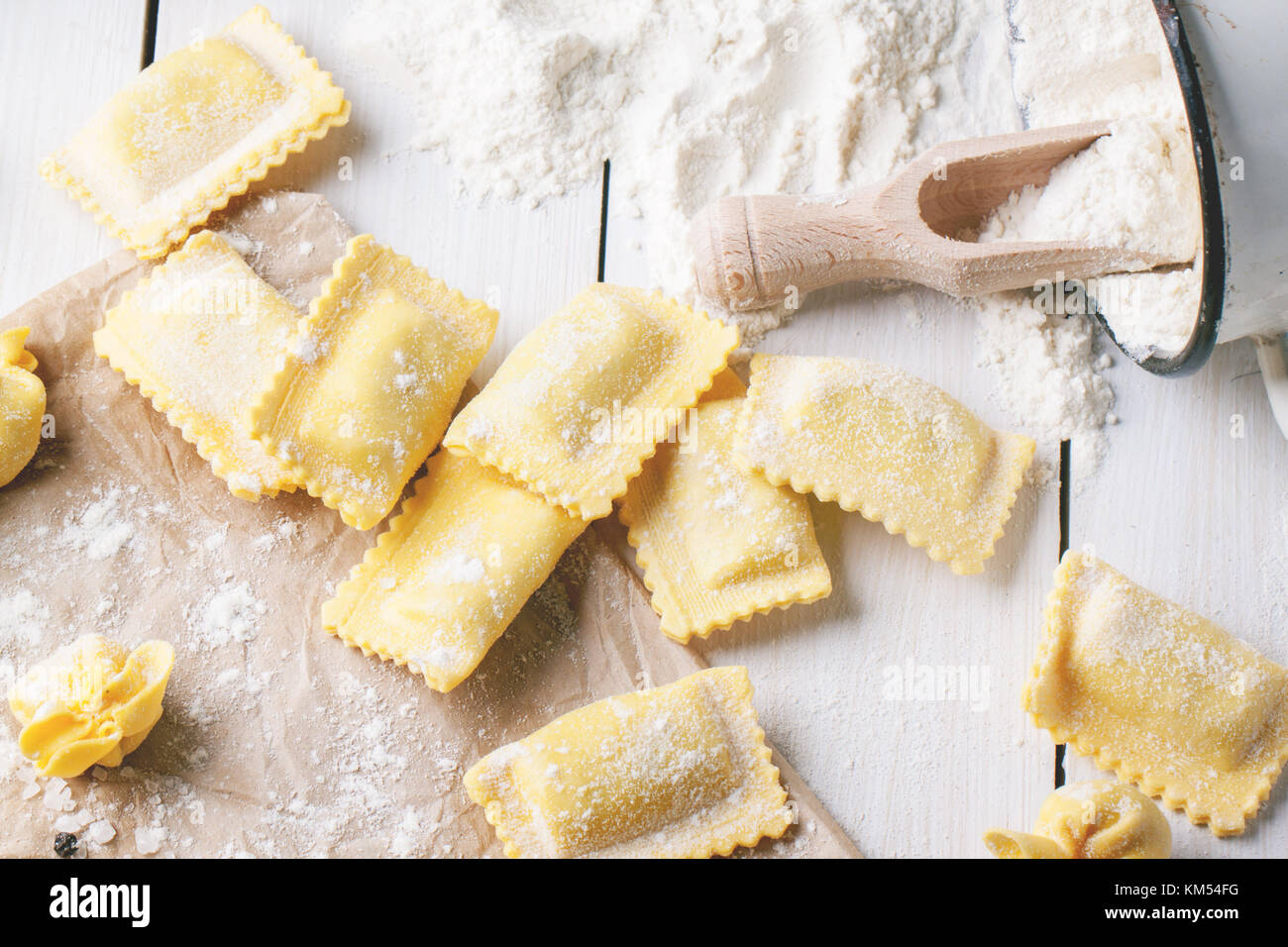 Top view on homemade pasta ravioli and perle on white wooden table with ...