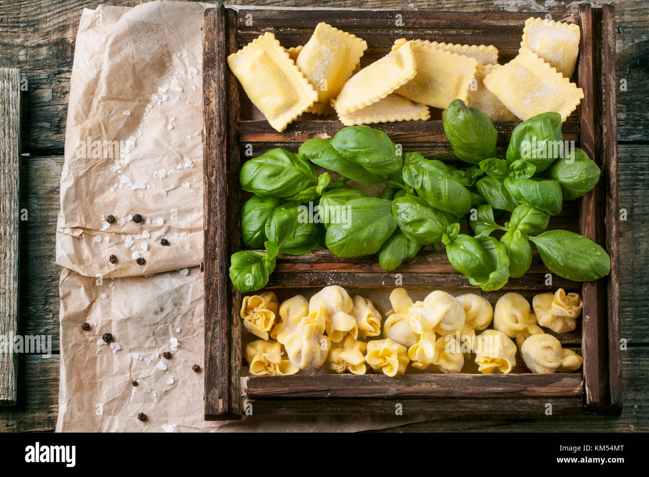 Top view on wooden box with homemade pasta ravioli and perle with fresh ...