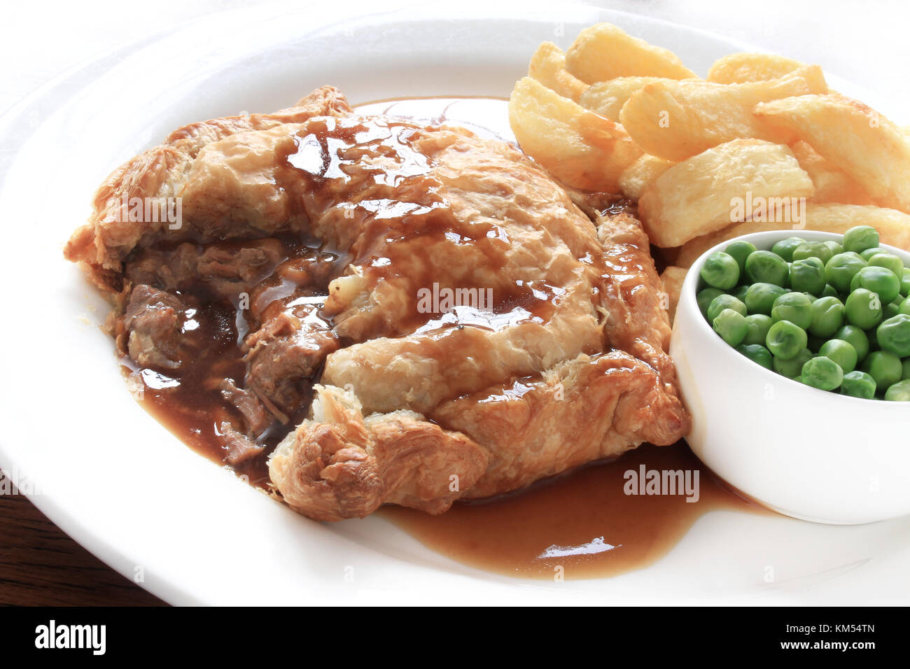 traditional beef steak pie with chips and peas Stock Photo - Alamy