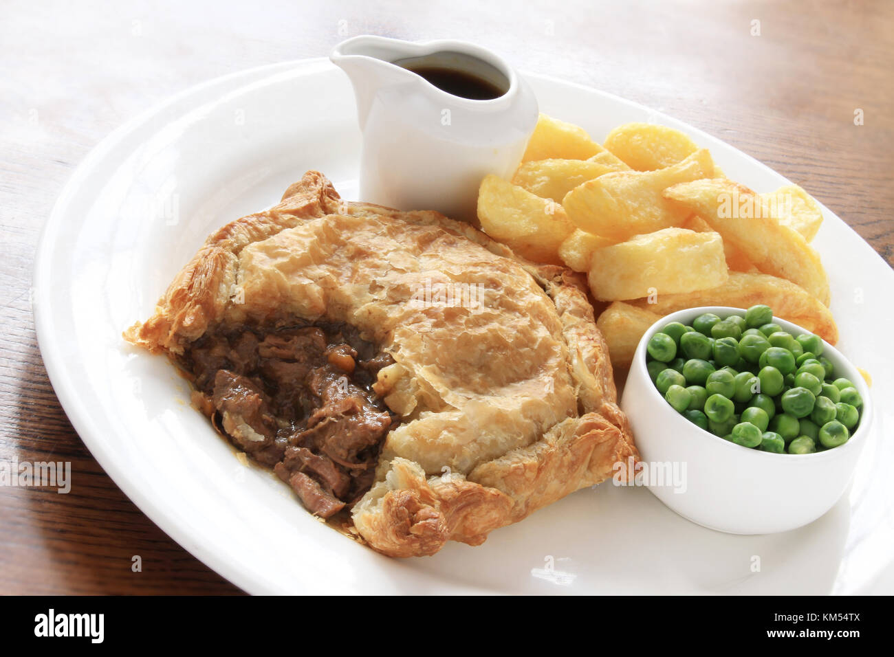 traditional beef steak pie with chips and peas Stock Photo - Alamy