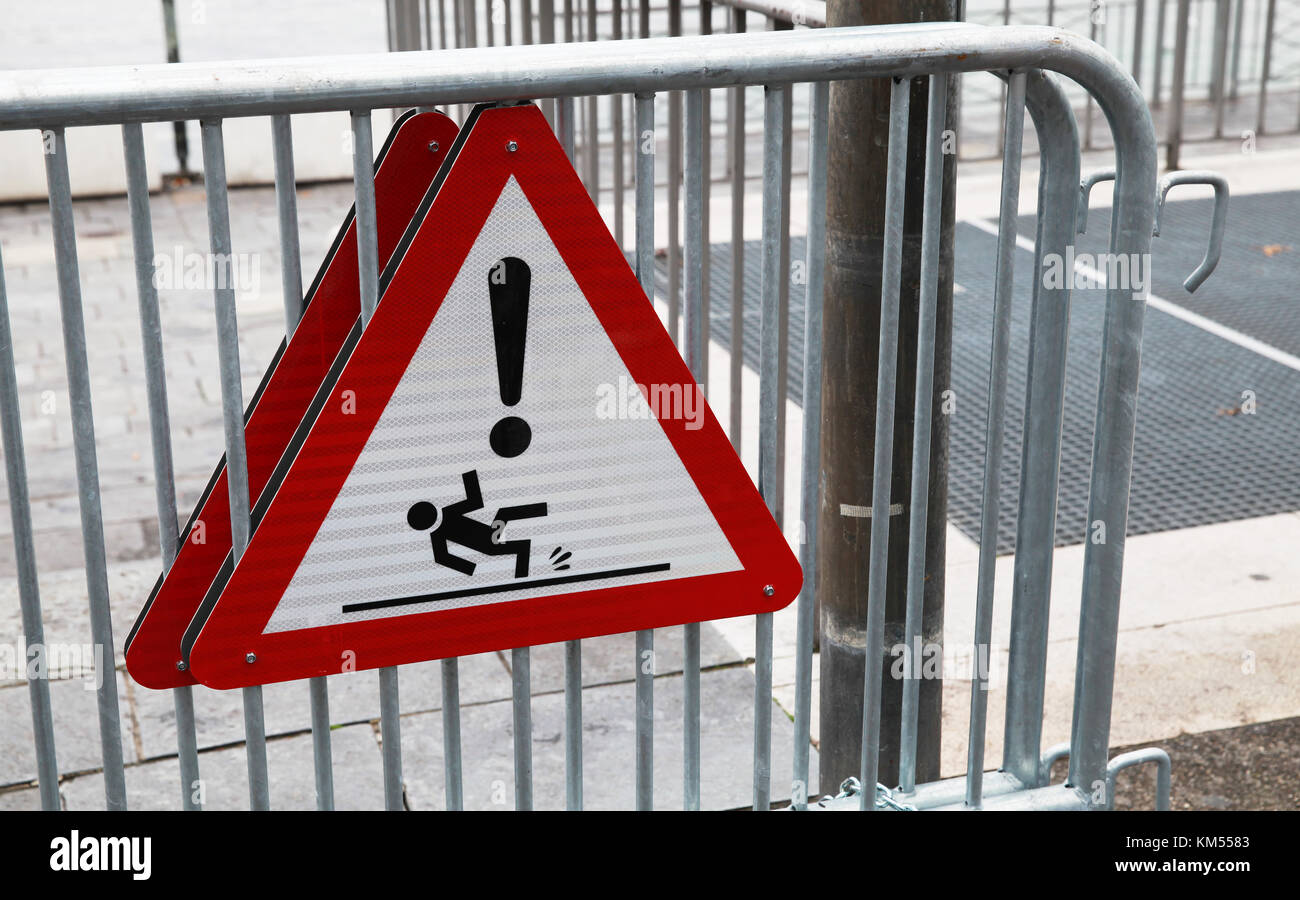 Caution wet floor; triangle warning sign mounted on steel street ...