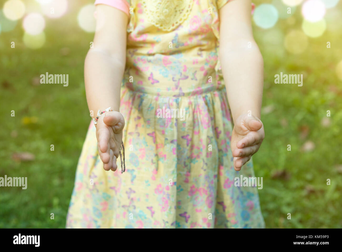 Child with opened arms and hand in a position, as if she is holding ...