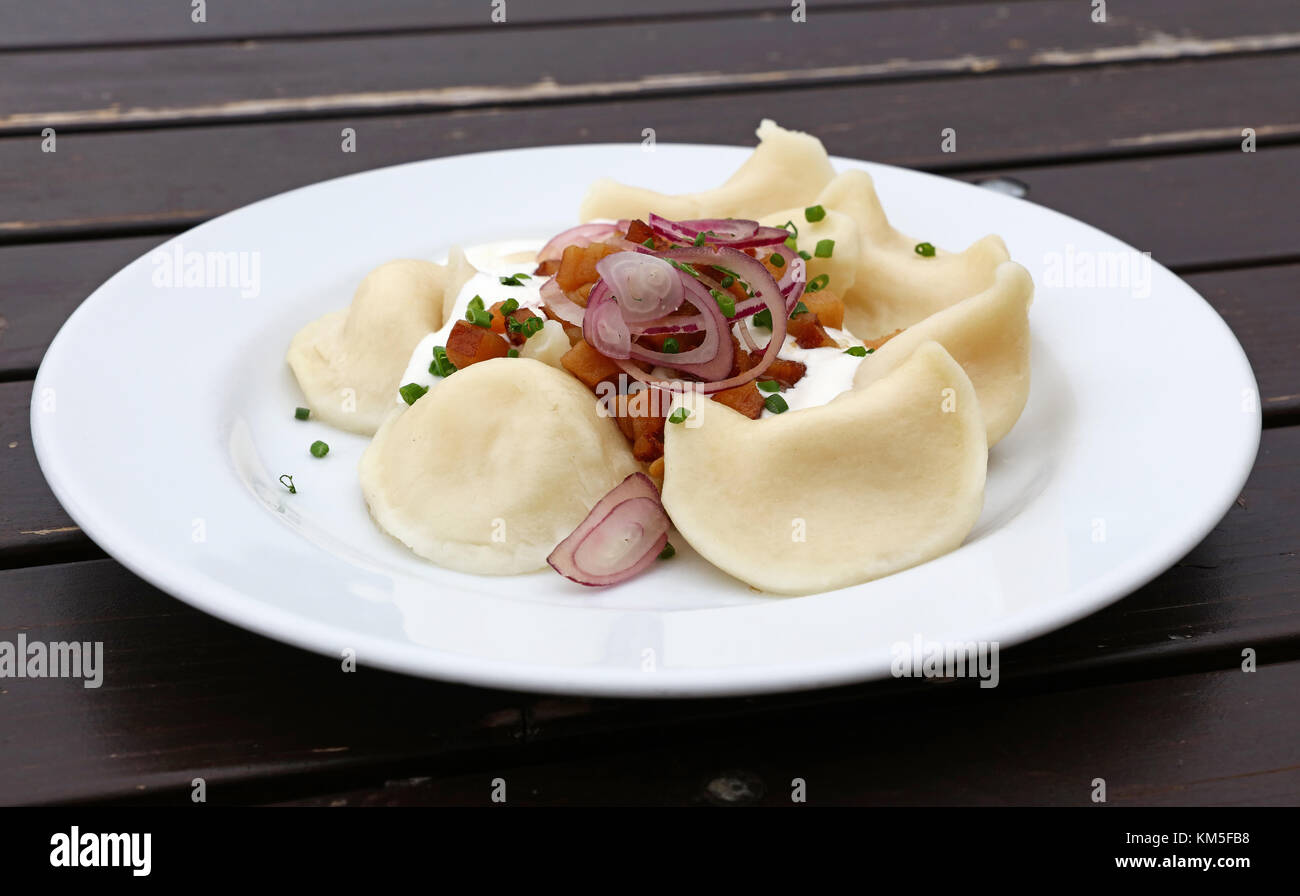 Plate of pierogi or varenyky stuffed filled dumplings with sour cream ...