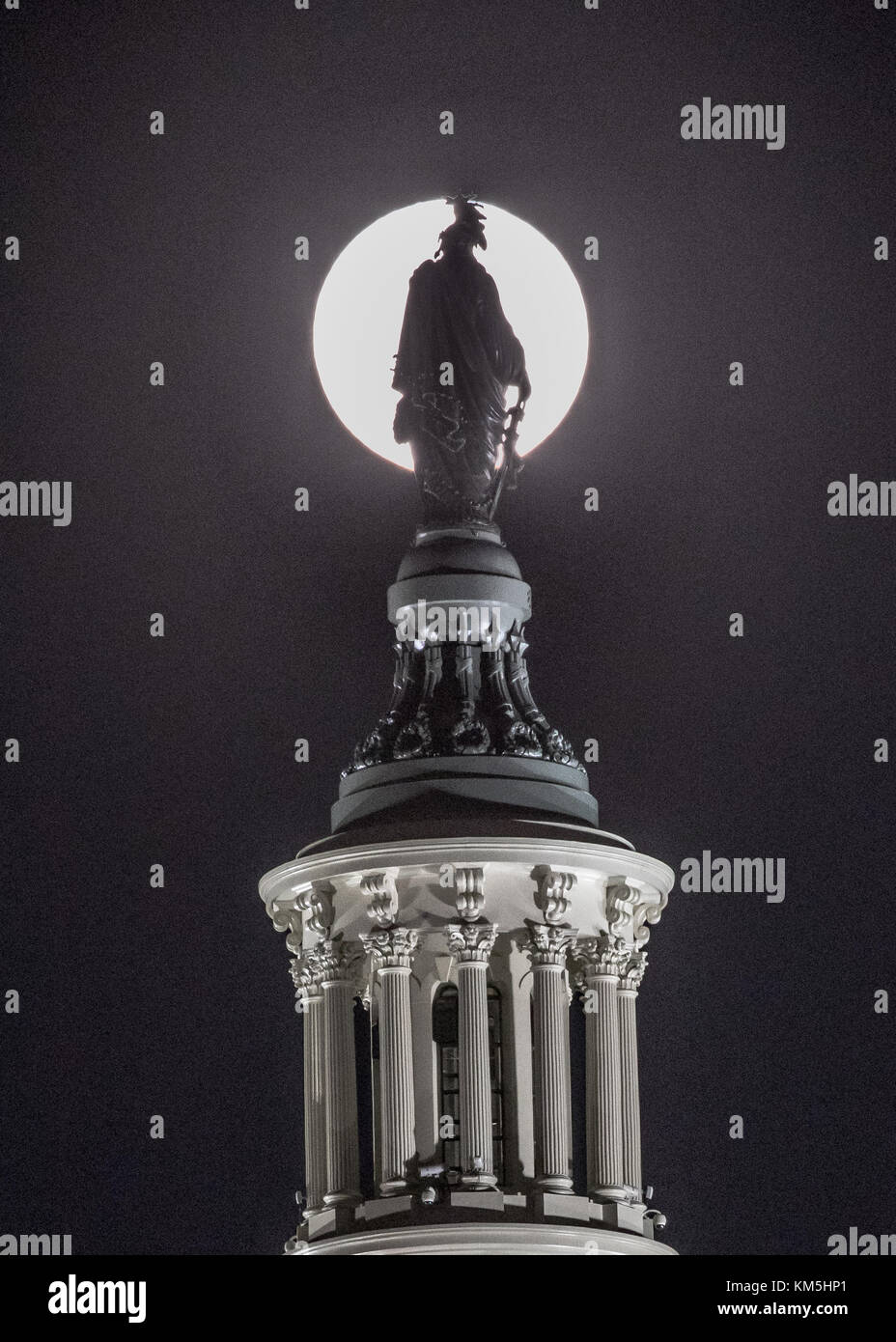 A supermoon is observed behind the Statue of Freedom atop the United ...