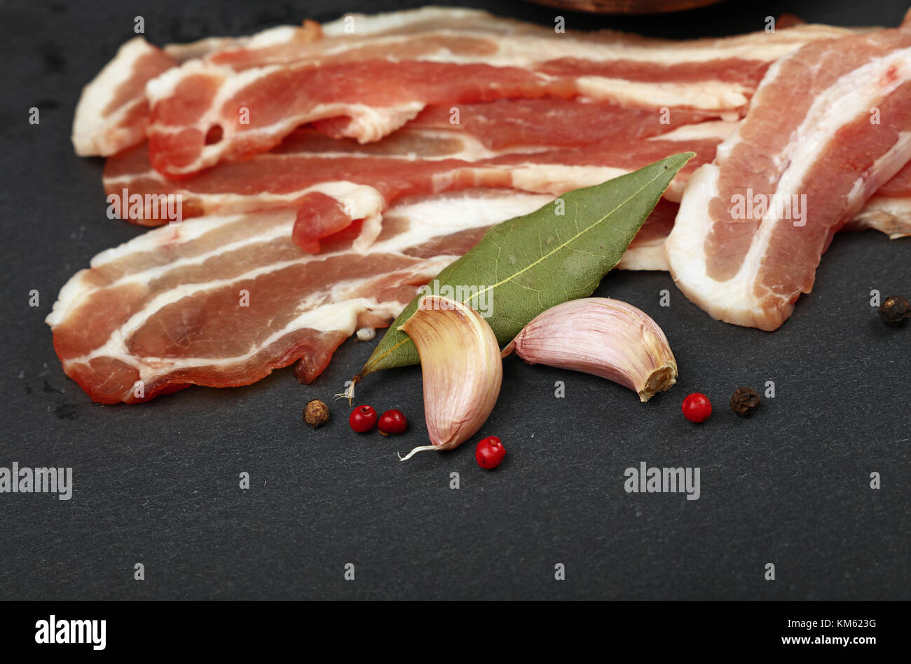 Raw pork bacon slices, rashers, spices, rose peppercorns, garlic and ...