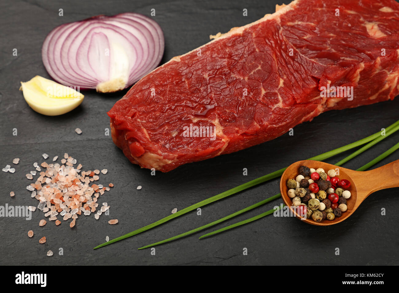 One raw beefsteak red meat cut, spices, peppercorn in wooden scoop ...