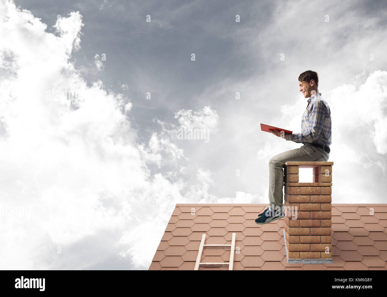 Handsome man on brick roof against cloud scape reading book Stock Photo ...