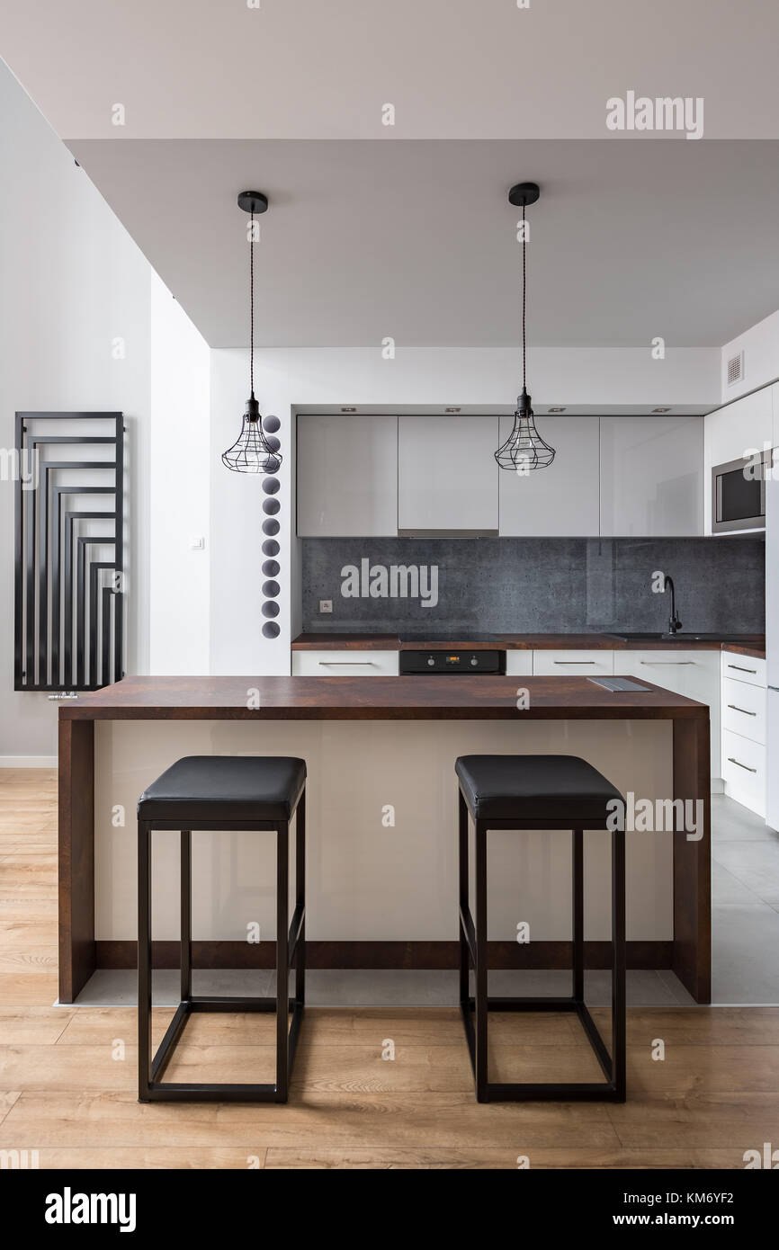 Modern kitchen with table, stools and decorative wall radiator Stock ...