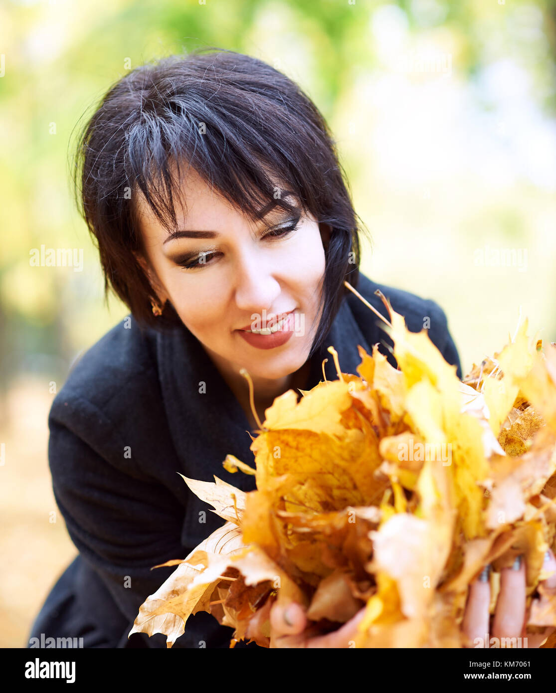 beautiful woman portrait with handful of leaves in autumn outdoor ...