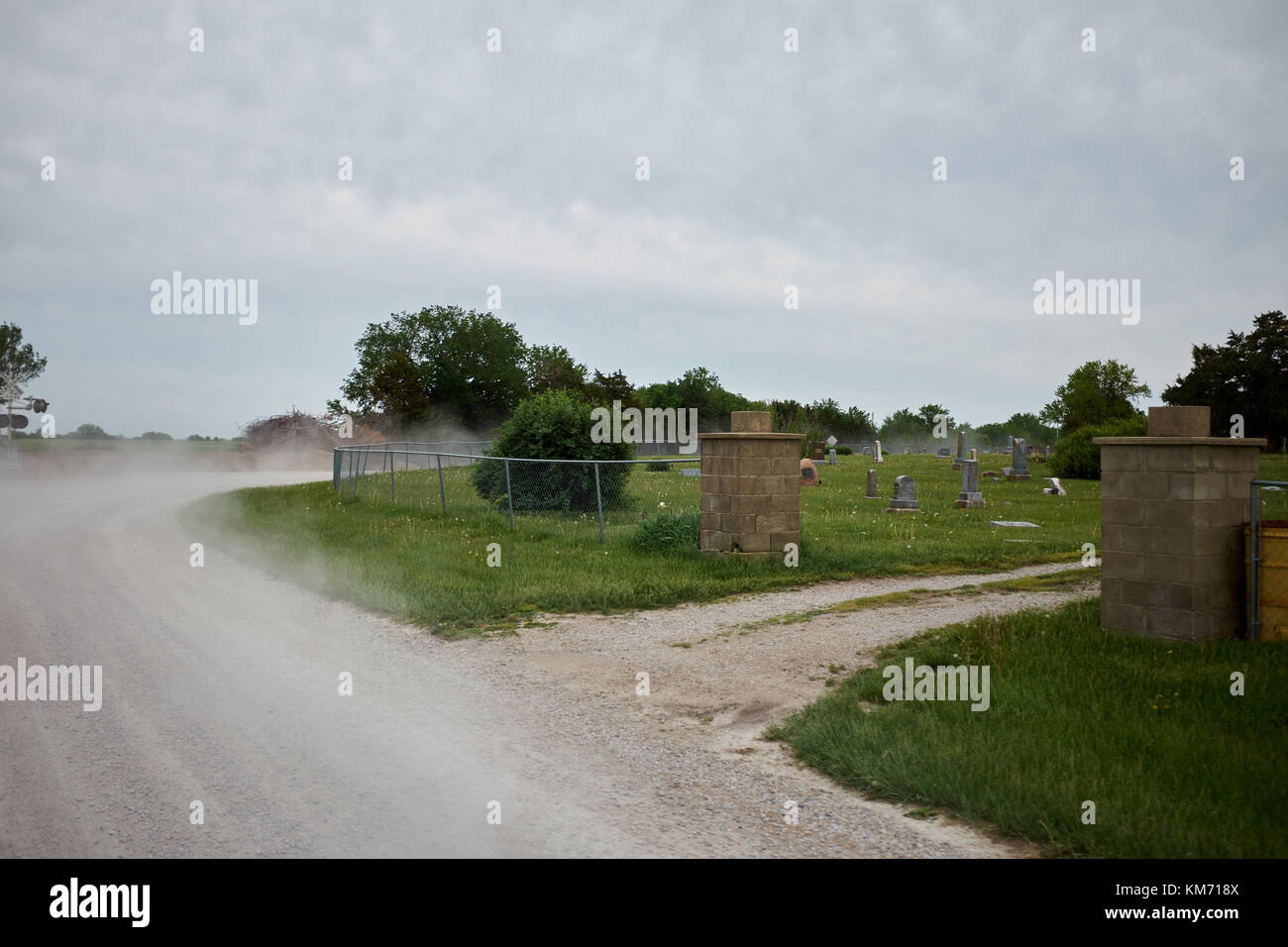 Dirt road in the countryside with a cloud of dust disappearing around a ...