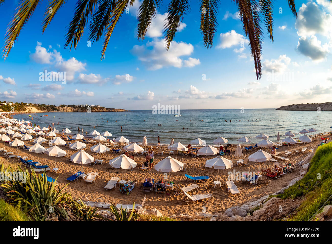 Tourists relaxing on the beach in the summer vacation. Peyia village ...