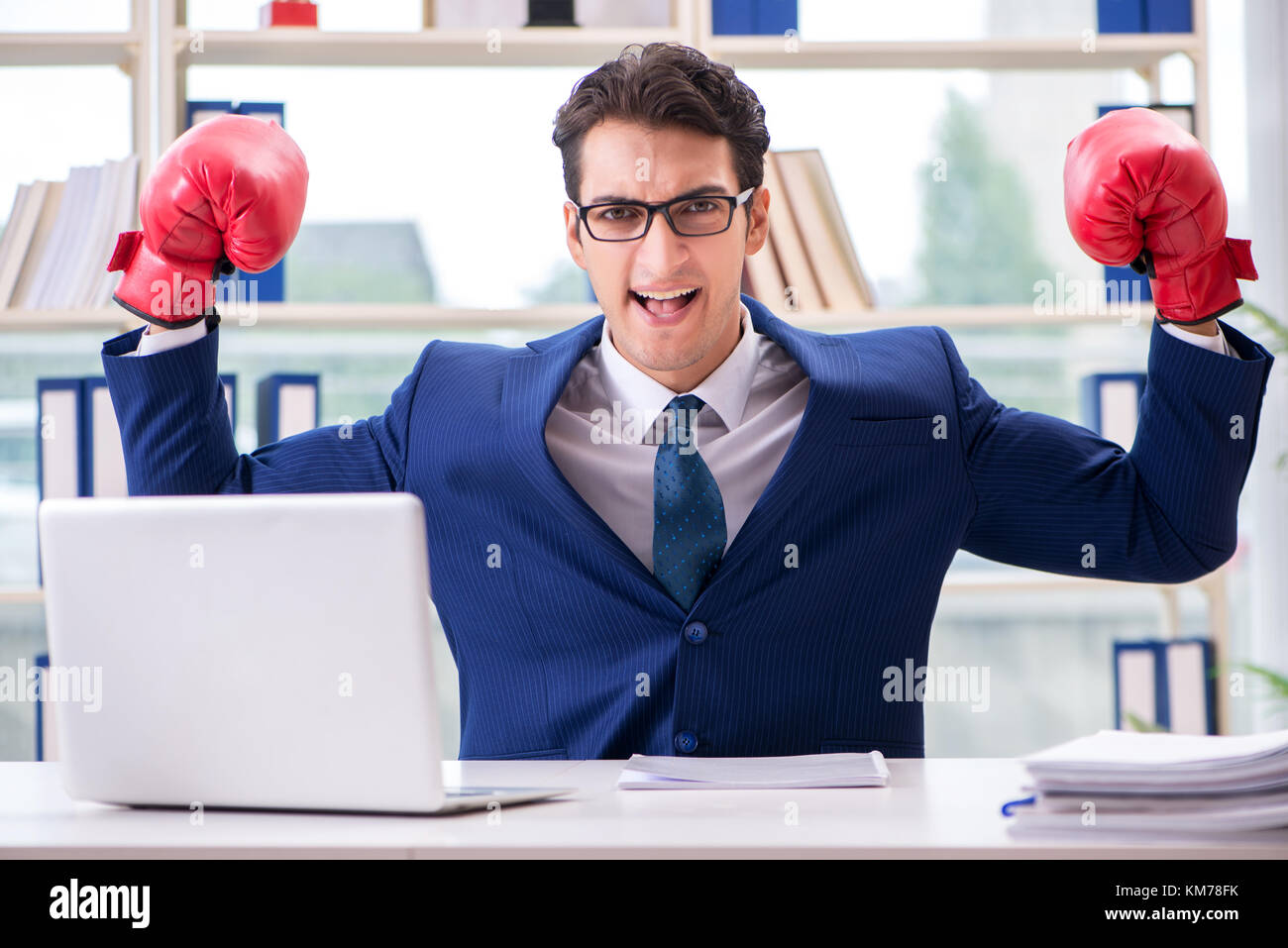 Businessman with boxing gloves angry in office Stock Photo - Alamy