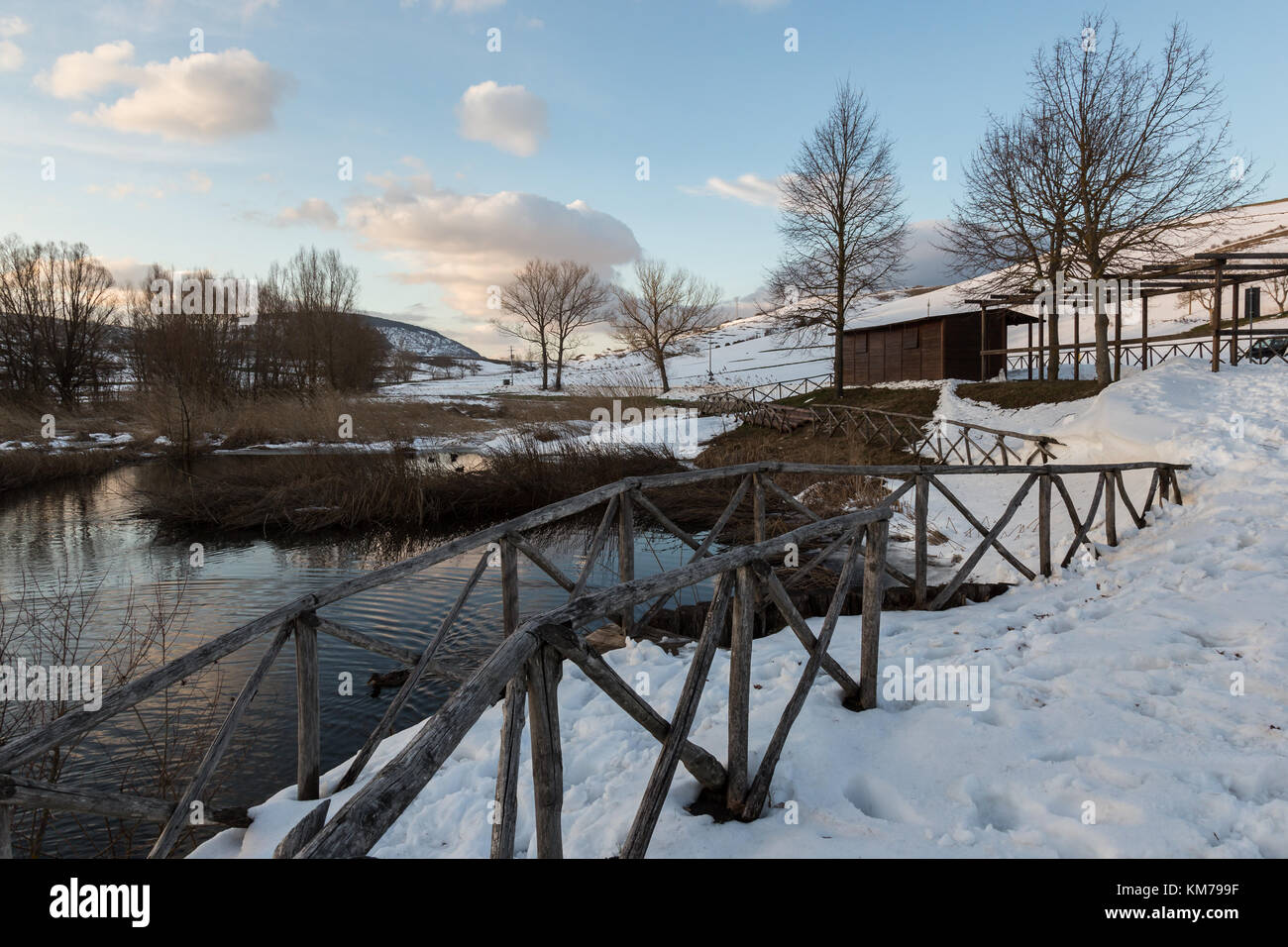 Colfiorito (Umbria) lake in winter, with snow all around, trees and a ...