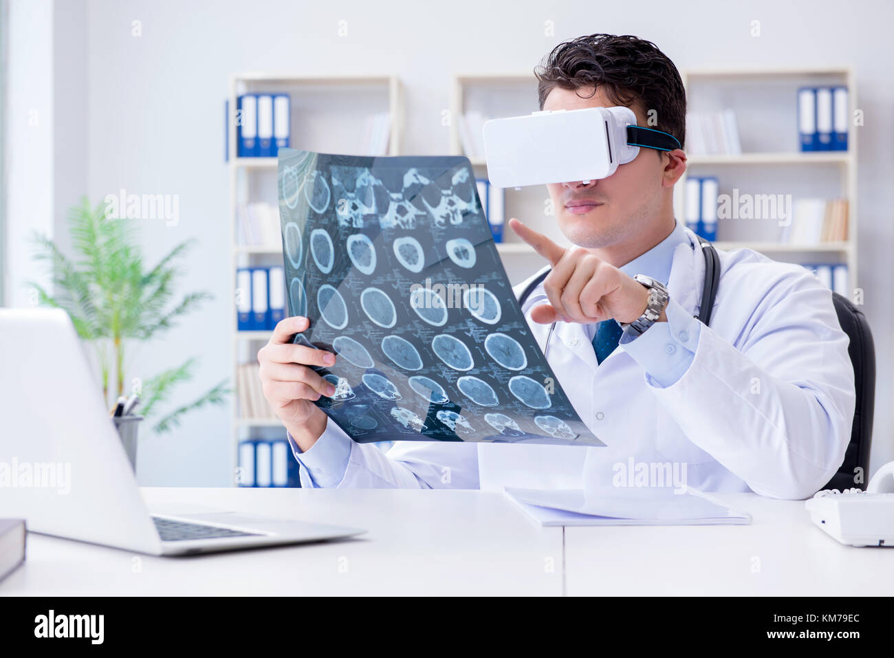 Young doctor looking at MRI scan through VR glasses Stock Photo - Alamy