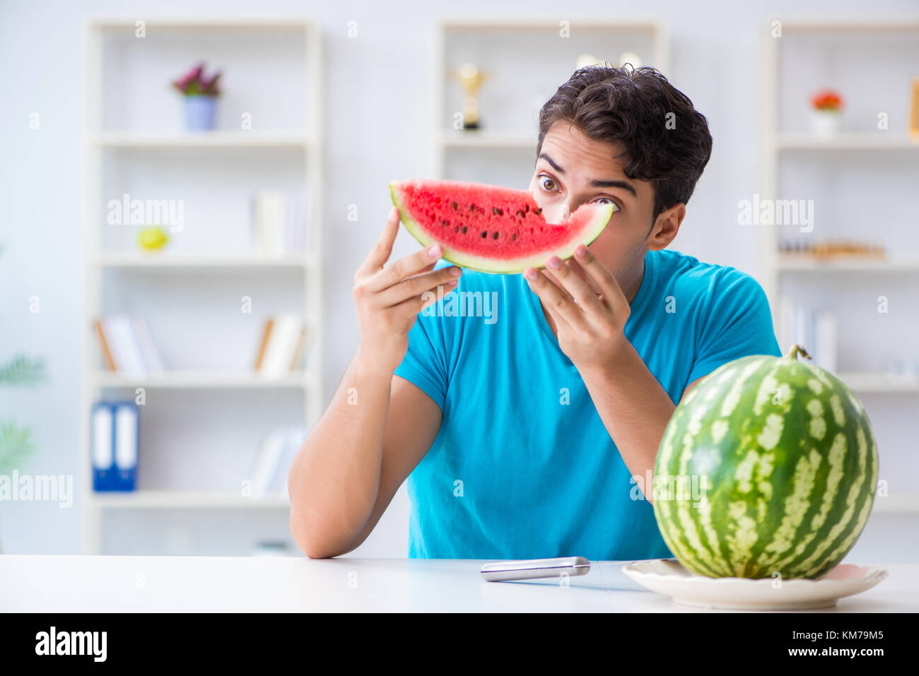 Man eating watermelon at home Stock Photo - Alamy