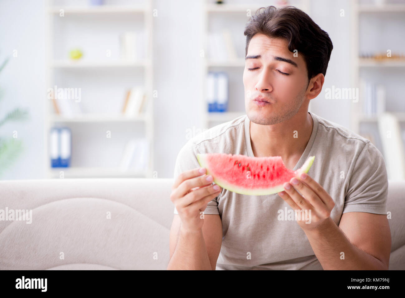 Man eating watermelon at home Stock Photo - Alamy