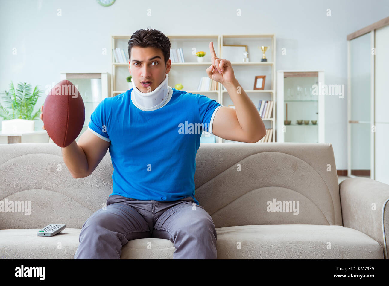 Man with neck injury watching american football at home Stock Photo - Alamy