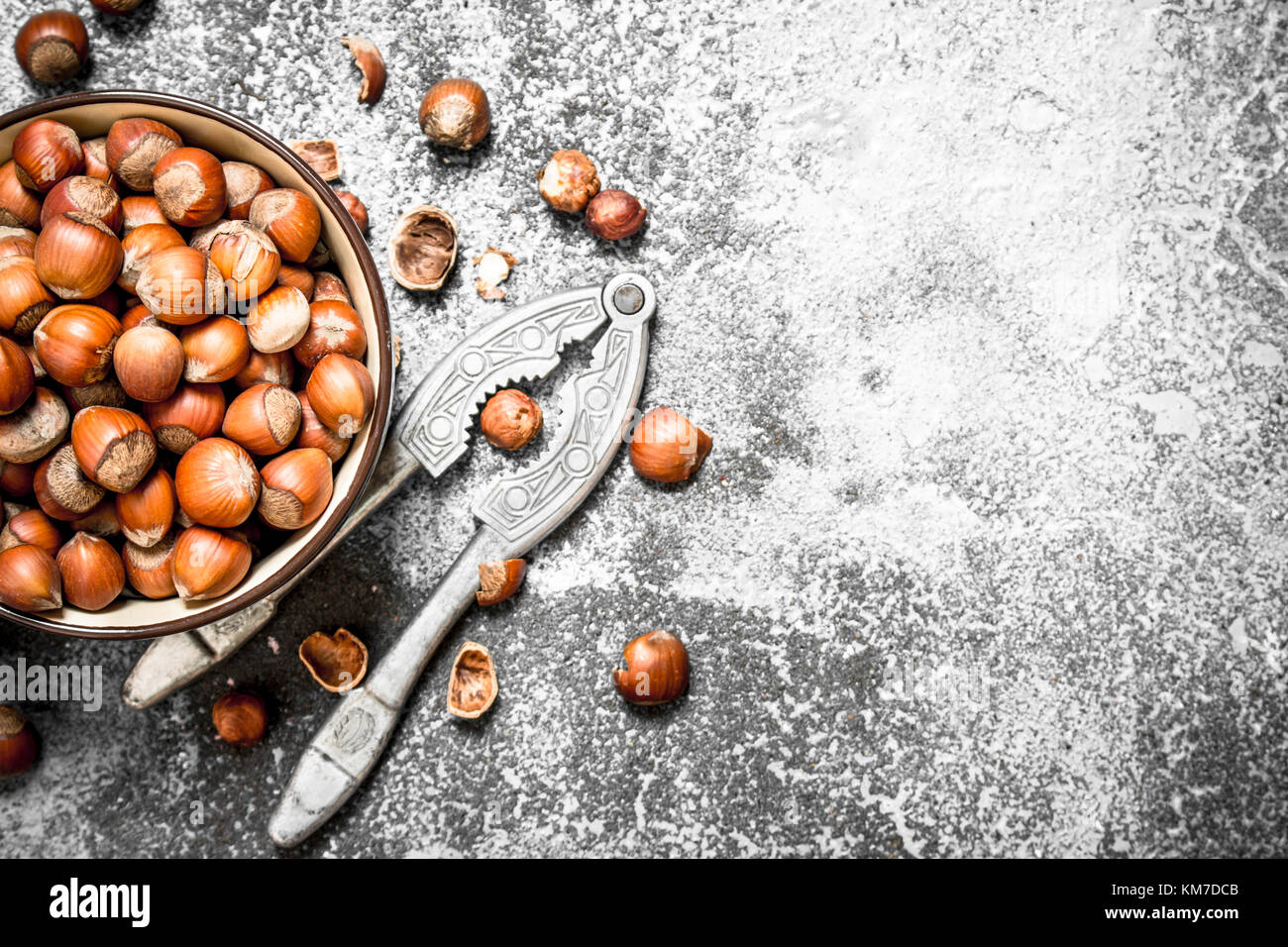 Hazelnuts in a bowl with a Nutcracker. On rustic background Stock Photo ...