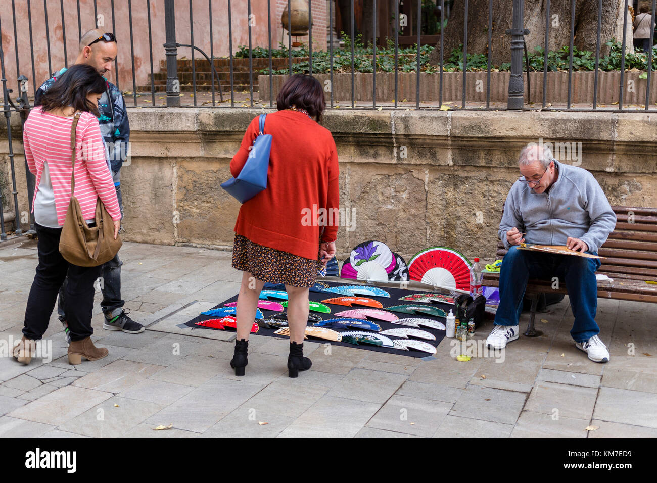 Man selling fans on the street in Malaga, Spain Stock Photo - Alamy