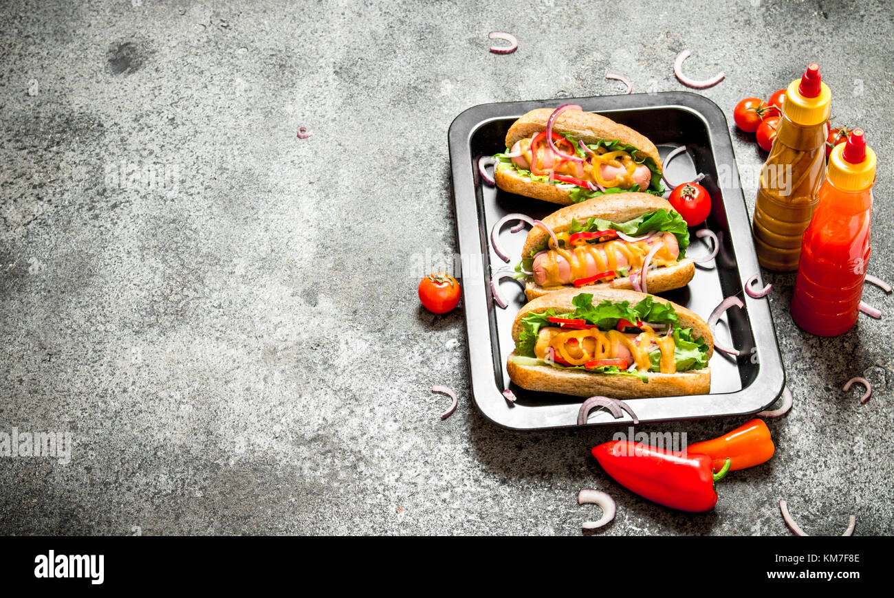 Street food. Hot dogs with herbs and vegetables in the pan.On rustic ...