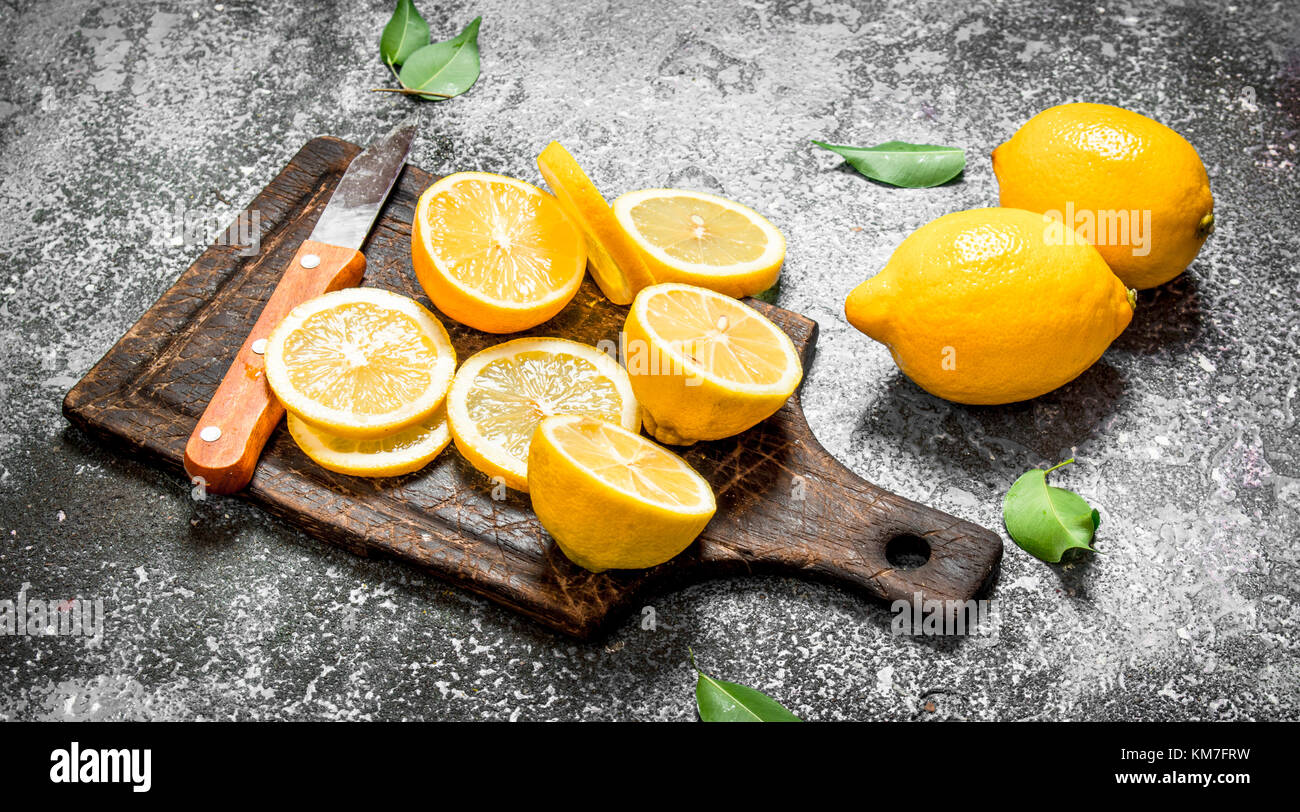 Sliced ripe lemon on the old Board. On rustic background Stock Photo ...