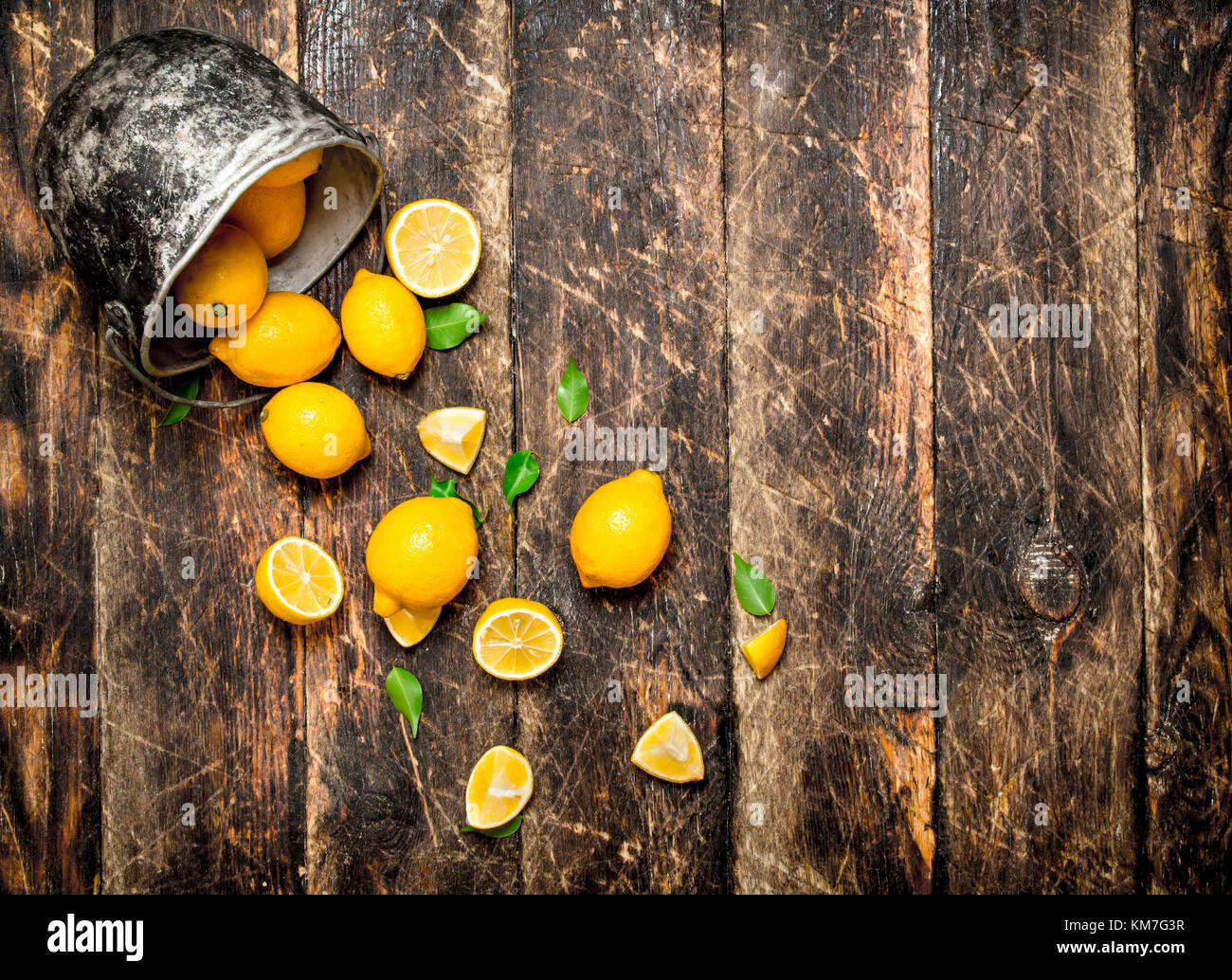 Ripe lemons in the old bucket. On wooden background Stock Photo - Alamy