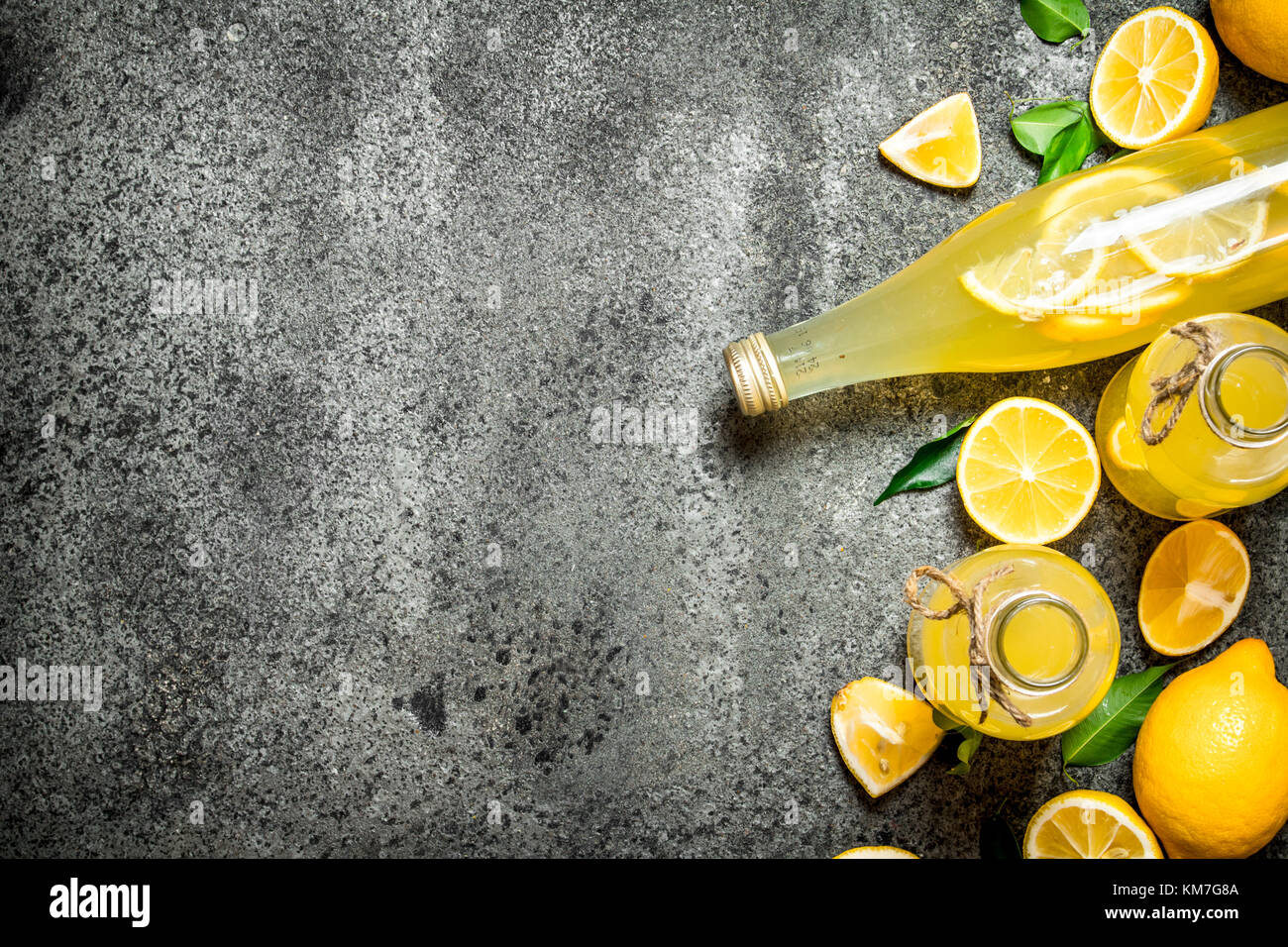 Lemonade in bottles with green leaves. On rustic background Stock Photo ...