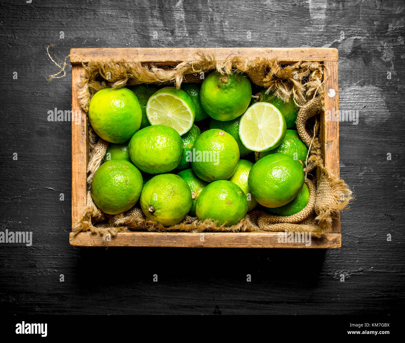 Fresh limes in the old box. On a black chalkboard Stock Photo - Alamy
