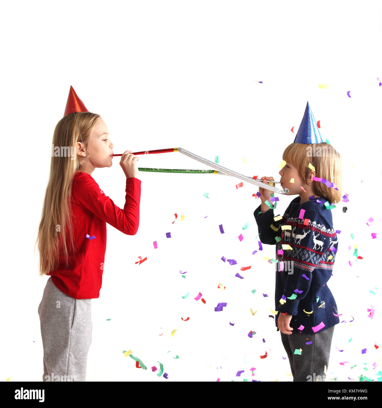 Children blowing party trumpets with confetti celebrating new year ...
