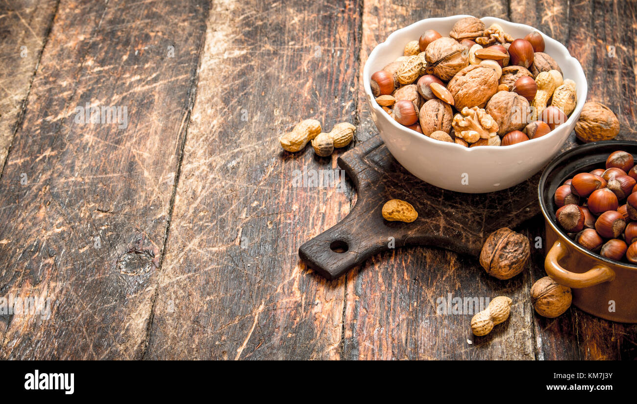 Various nuts in bowls. On wooden background Stock Photo - Alamy