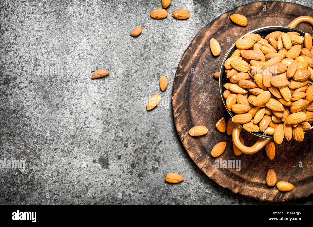 Almonds in a bowl. On rustic background Stock Photo - Alamy