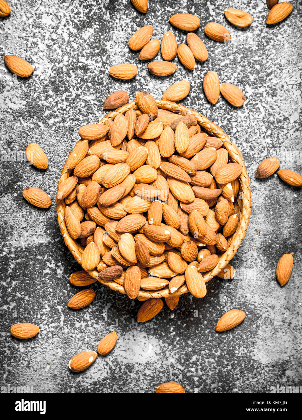 Almonds in the basket. On rustic background Stock Photo - Alamy