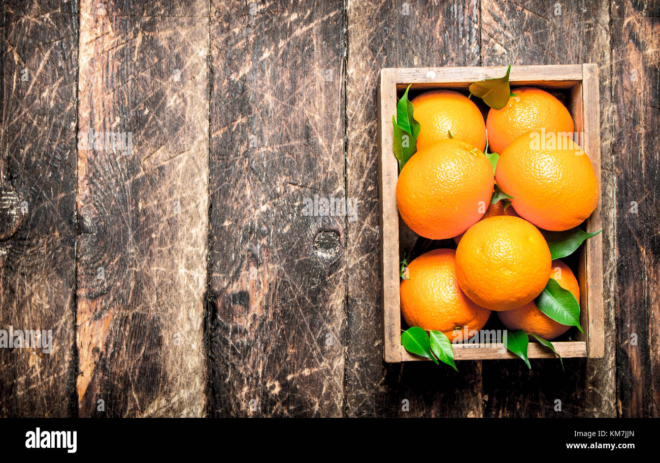 Fresh oranges in an old box. On wooden background Stock Photo - Alamy