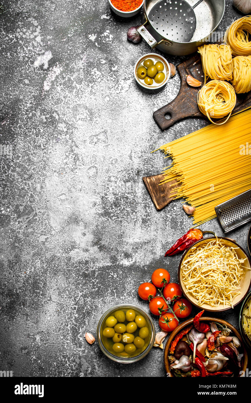 Pasta background. Various pasta with vegetables and spices.On rustic ...