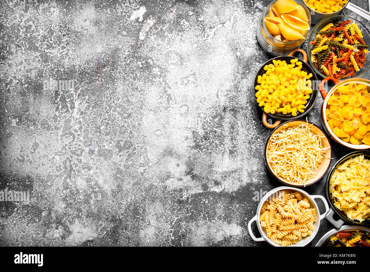 Pasta background. Many different pasta in bowls. On rustic background ...