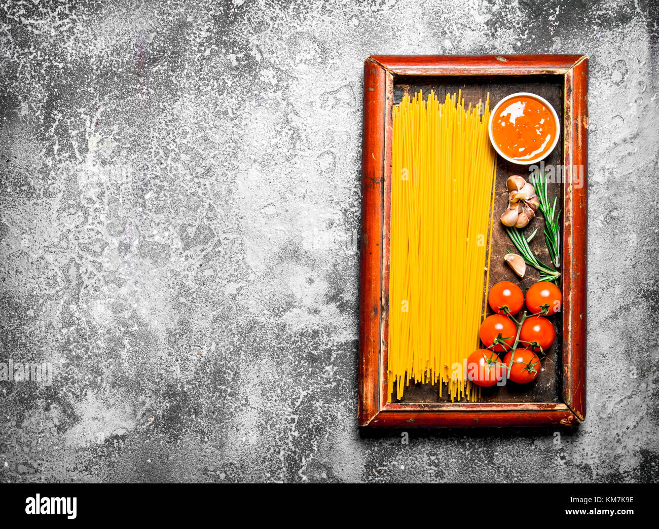 Pasta background. Spaghetti with sauce and tomatoes in the old tray. On ...