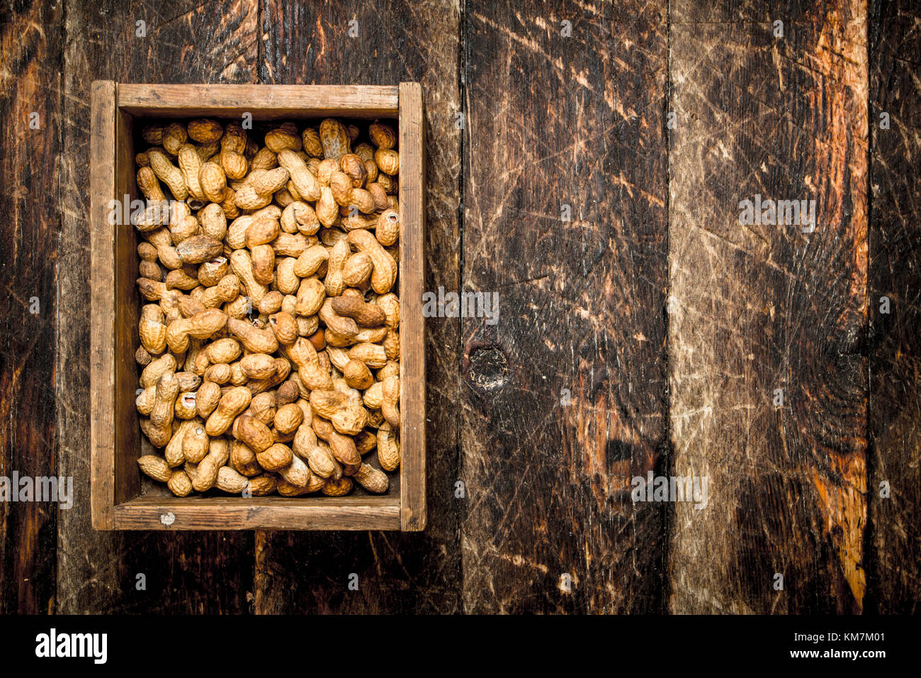 Peanuts in an old box. On wooden background Stock Photo - Alamy