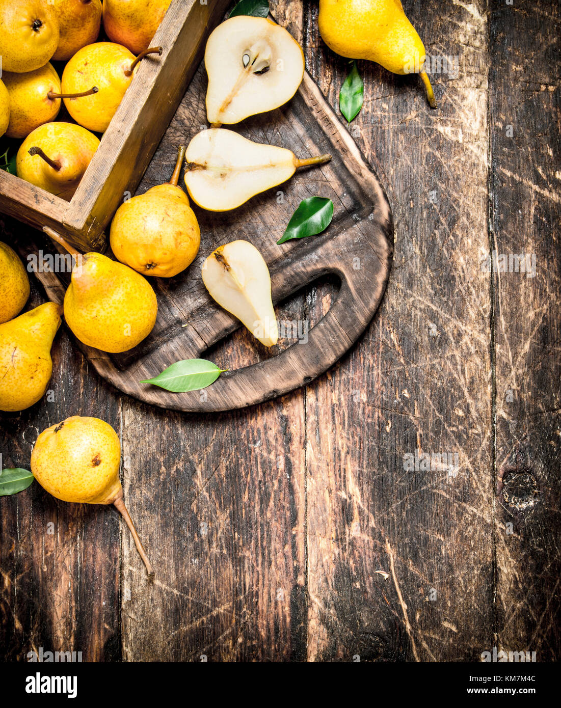 Ripe pears in a box with green leaves. On wooden background Stock Photo ...