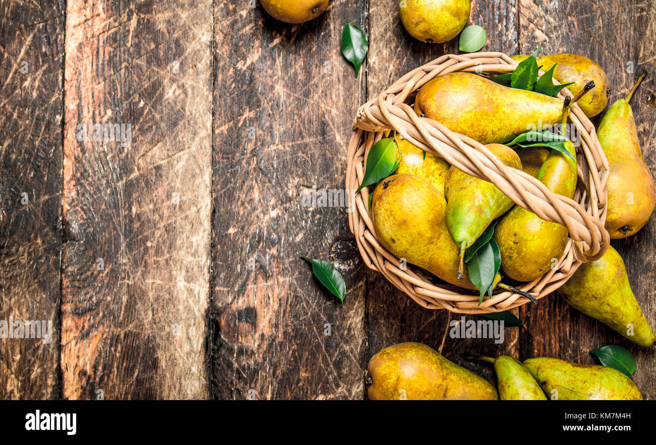 Fresh pears in the basket. On wooden background Stock Photo - Alamy