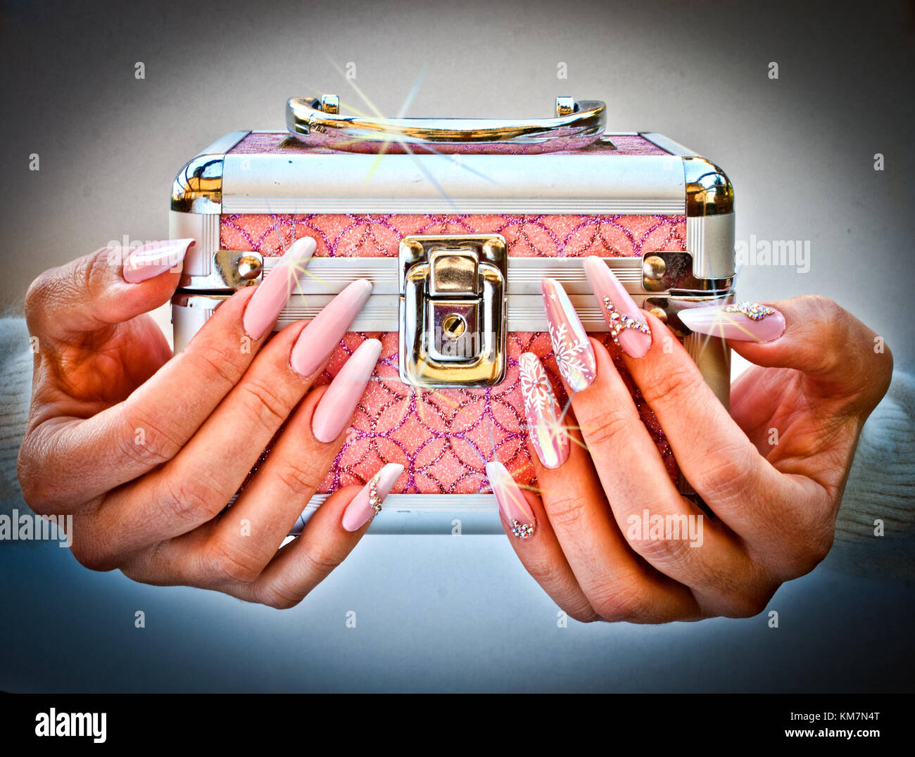 hands with nails decorated with snowflakes and glitter bring the box of ...