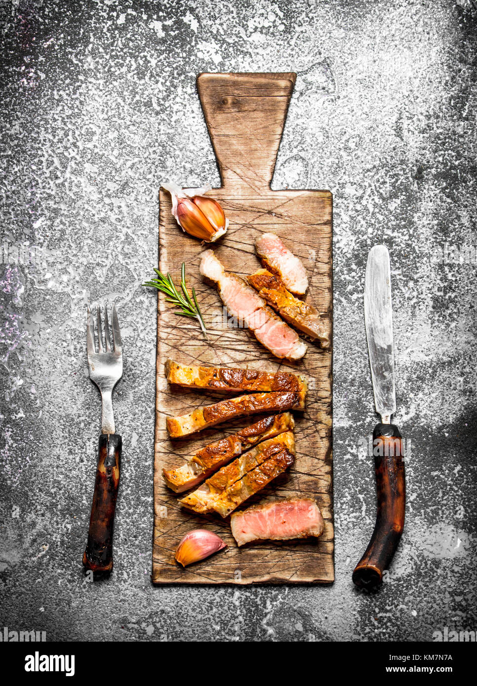 Meat grill. Cut a steak of roasted meat with spices. On rustic ...