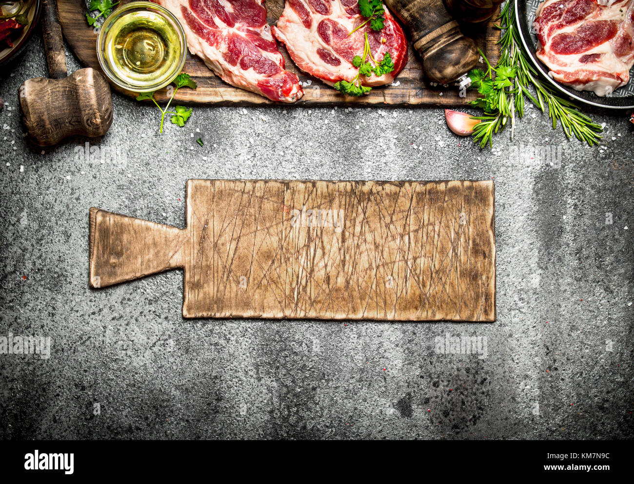 Raw meat background. Raw steak with herbs and spices on the old Board ...