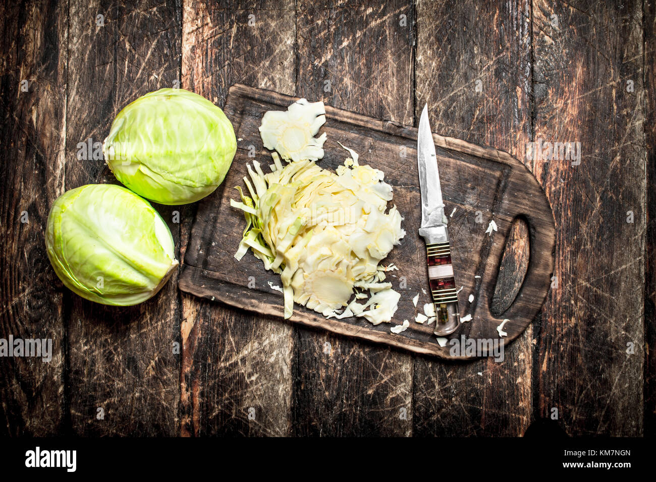 Shredded fresh cabbage on the Board. On the old wooden table Stock ...