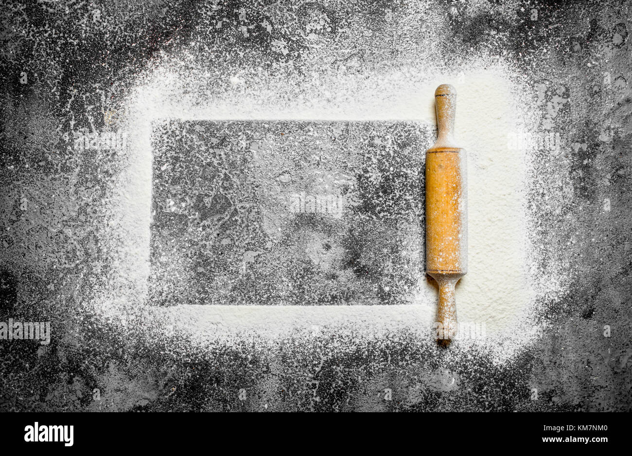 Baking background. Frame of sifted flour with a rolling pin. On rustic ...